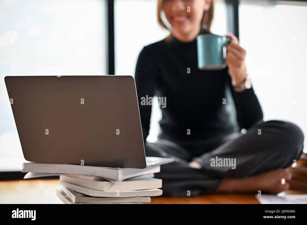 Female freelance writer having a morning coffee while working and using ...