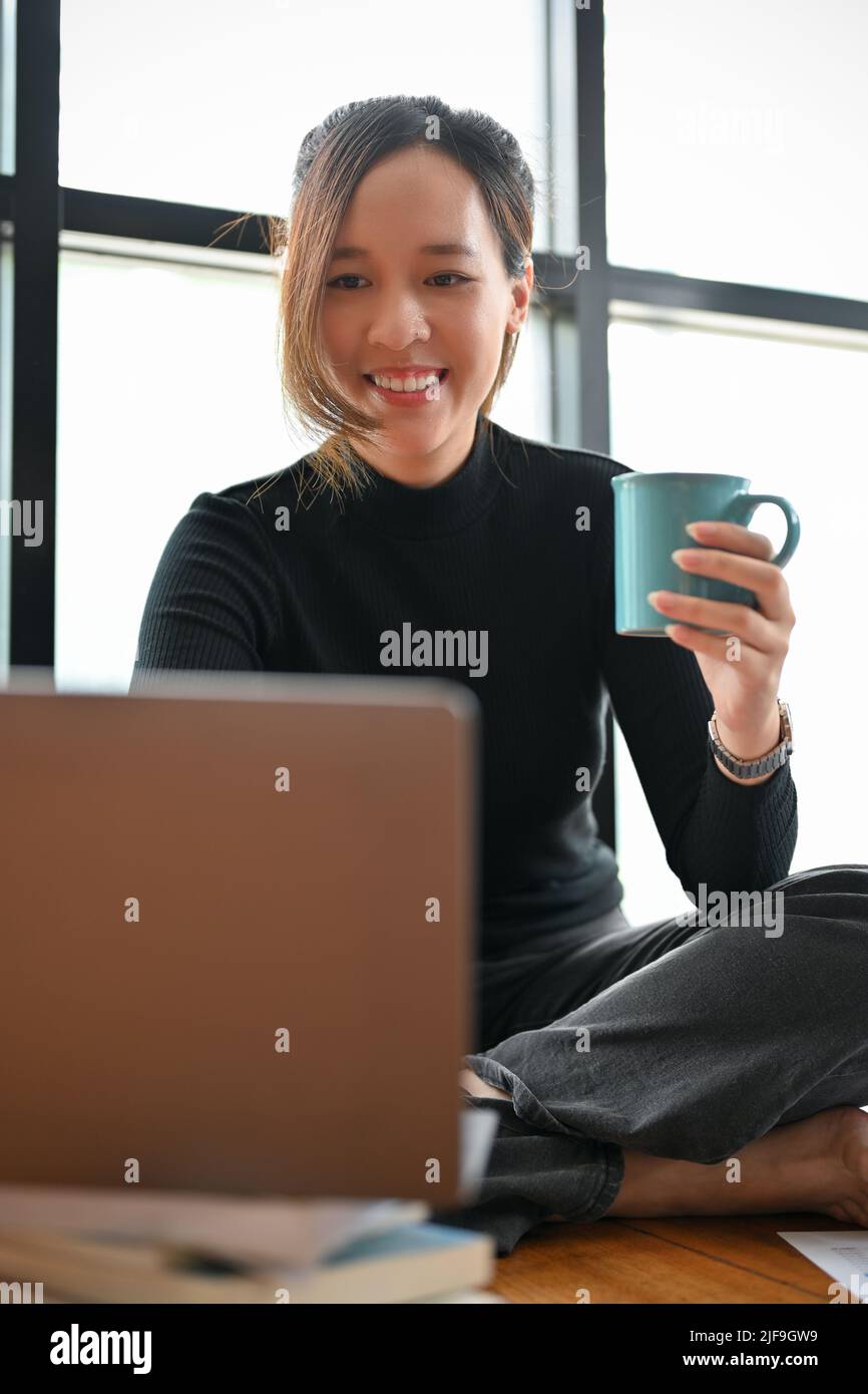 Beautiful young Asian female freelancer or female journalist working on ...