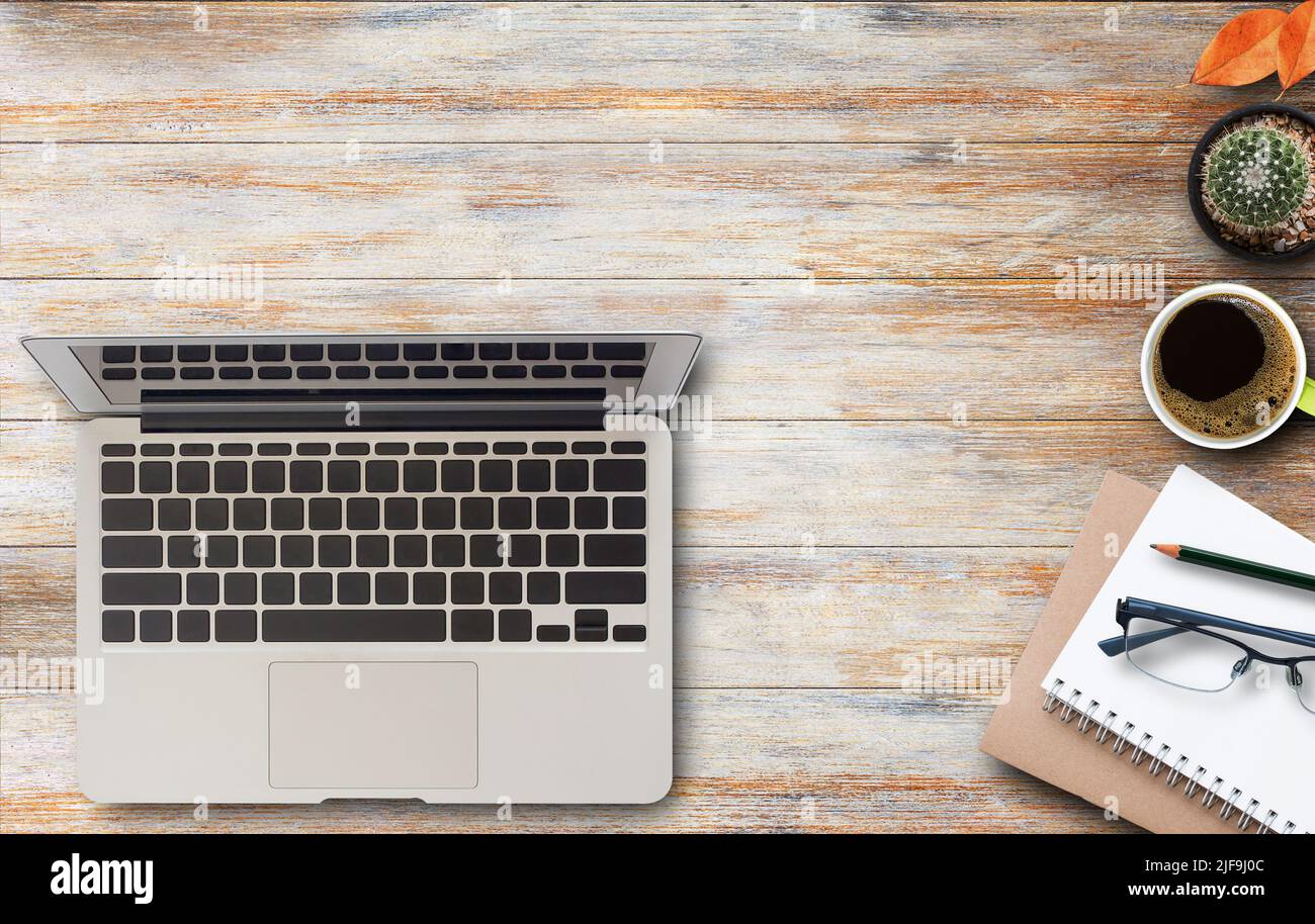Laptop computer with cup of coffee and notepad on old wooden table ...