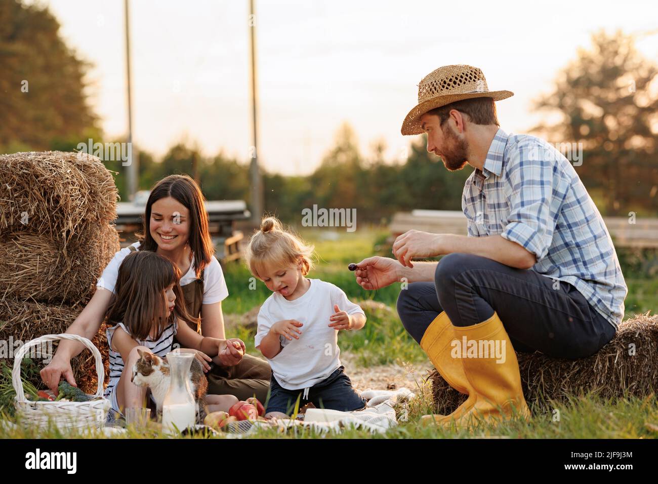 Happy young family having lunch at summer garden party. Mother, father ...