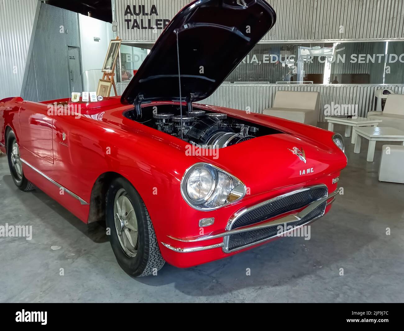 Old red Justicialista V8 roadster 1952. Open hood showing engine. Expo ...