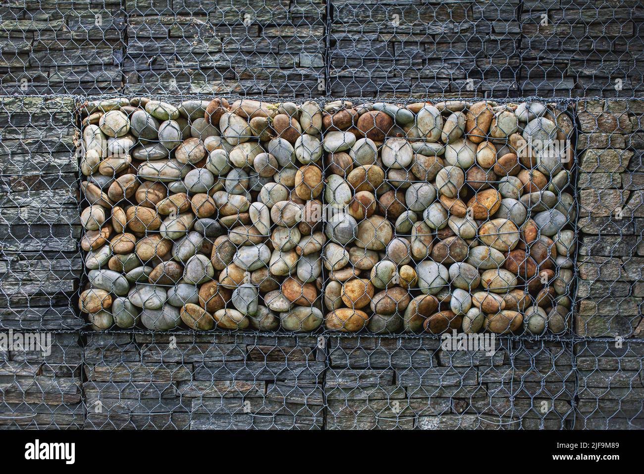 Slate and pebble wall in a park Stock Photo - Alamy