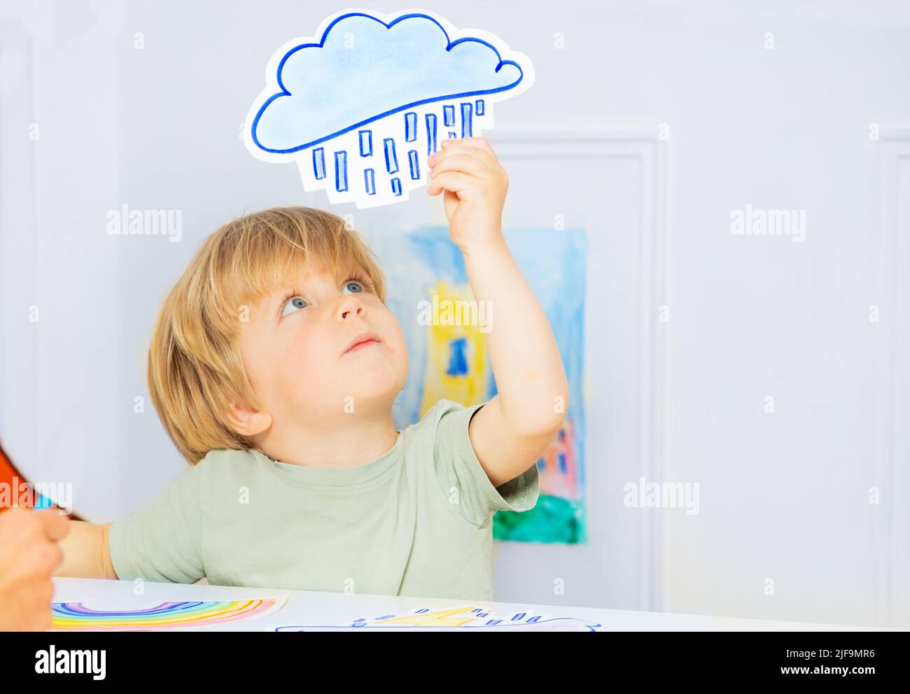 Boy in kindergarten class hold weather rain card Stock Photo - Alamy