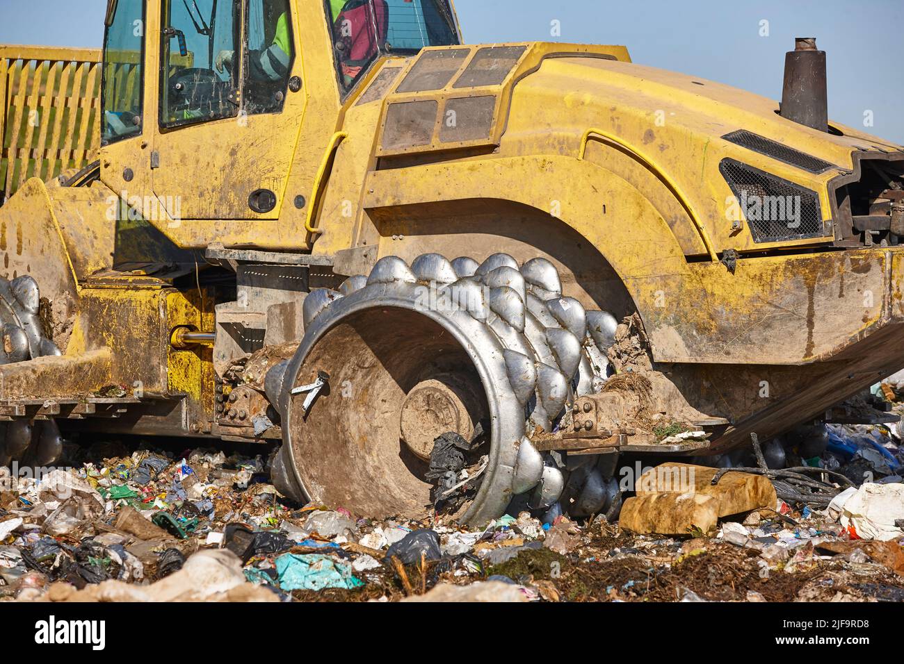 Heavy machinery shredding garbage in an open air landfill. Waste Stock ...