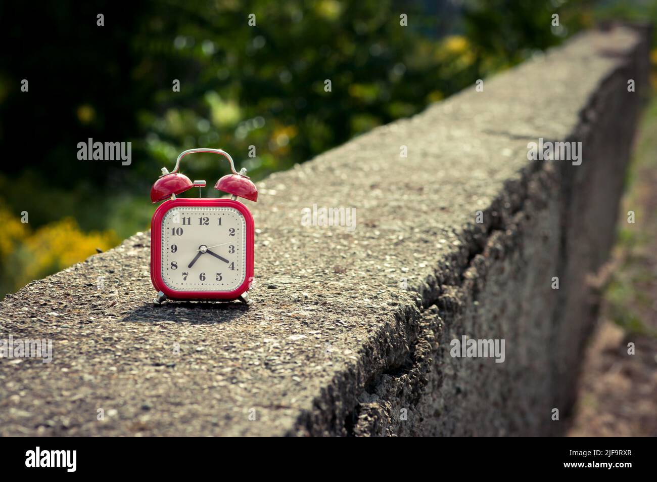 Red vintage style analog alarm clock on a concrete surface Stock Photo ...