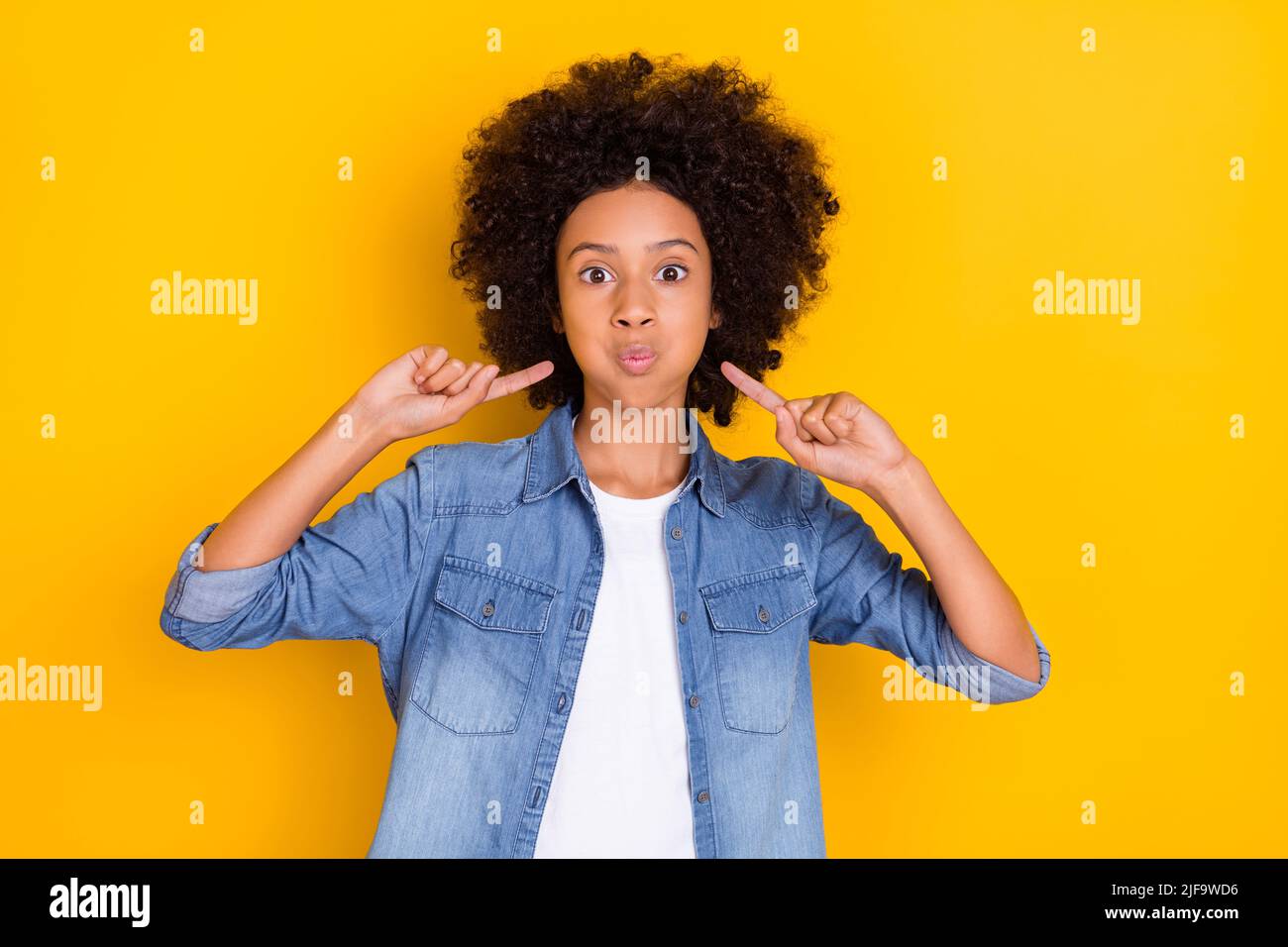 Portrait of attractive funny teen-aged girl blowing cheeks touching ...