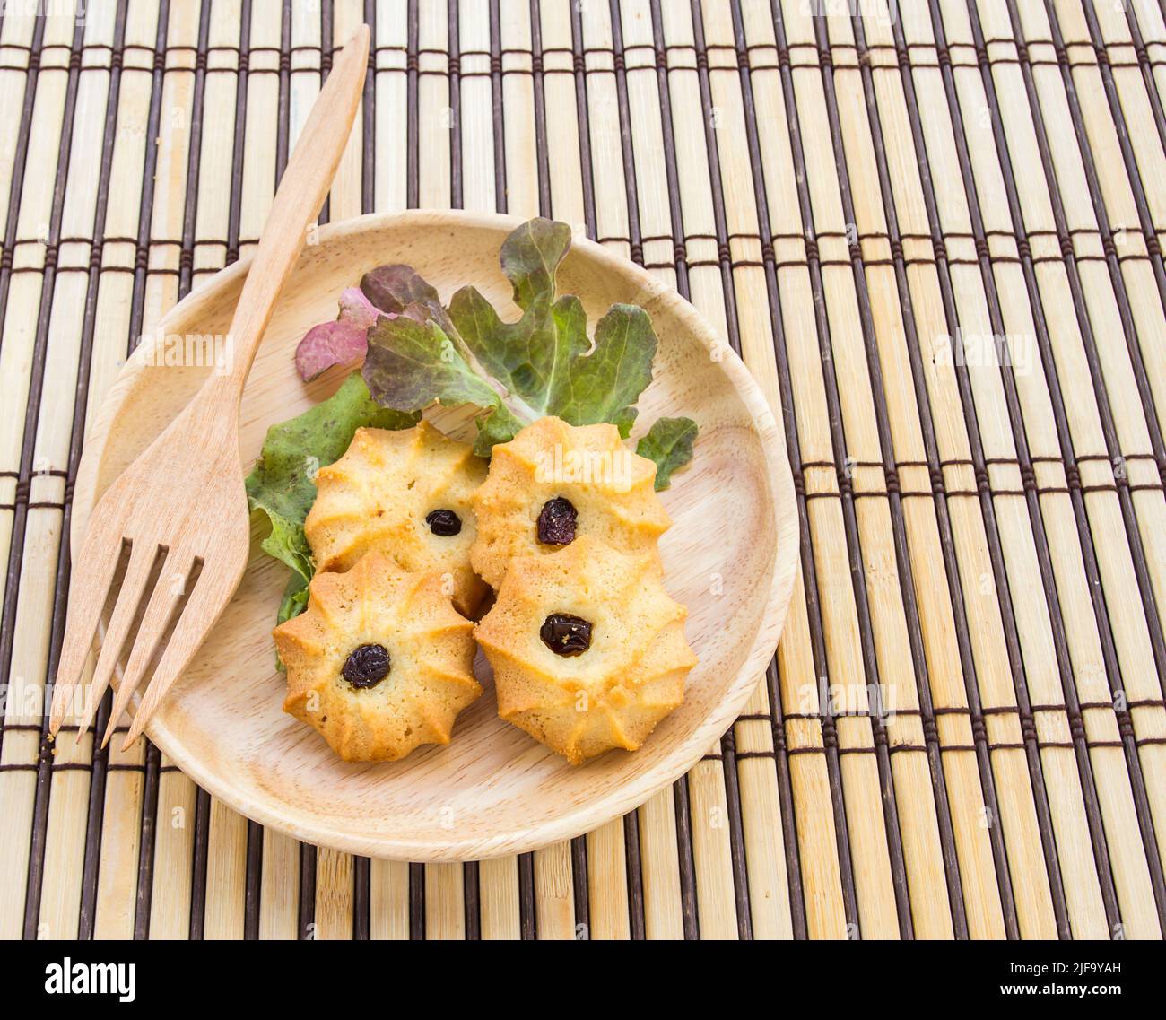 Cookies and lettuce leaves in wooden plate on wood table background ...