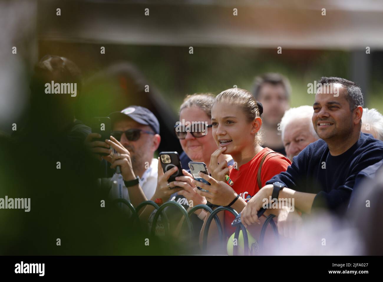 Spectators watch on as players practice on the practice courts during ...