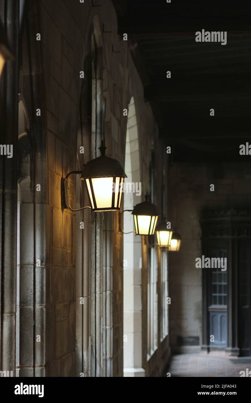 Vintage street light glowing on the old Gothic stone walls Stock Photo ...