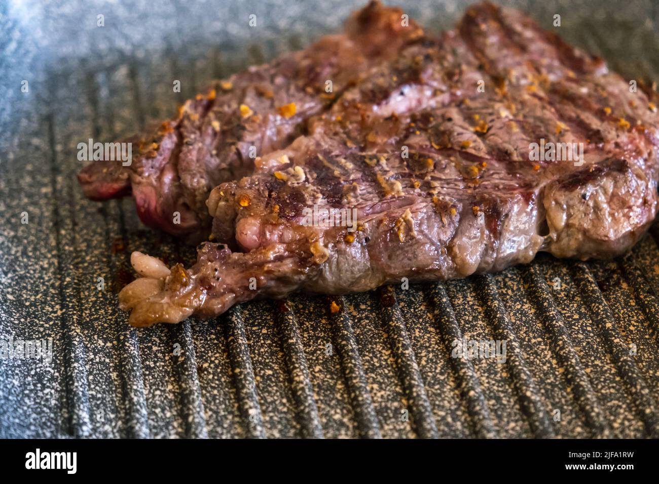Juicy beef meat steak cooking on griddle pan at professional kitchen ...