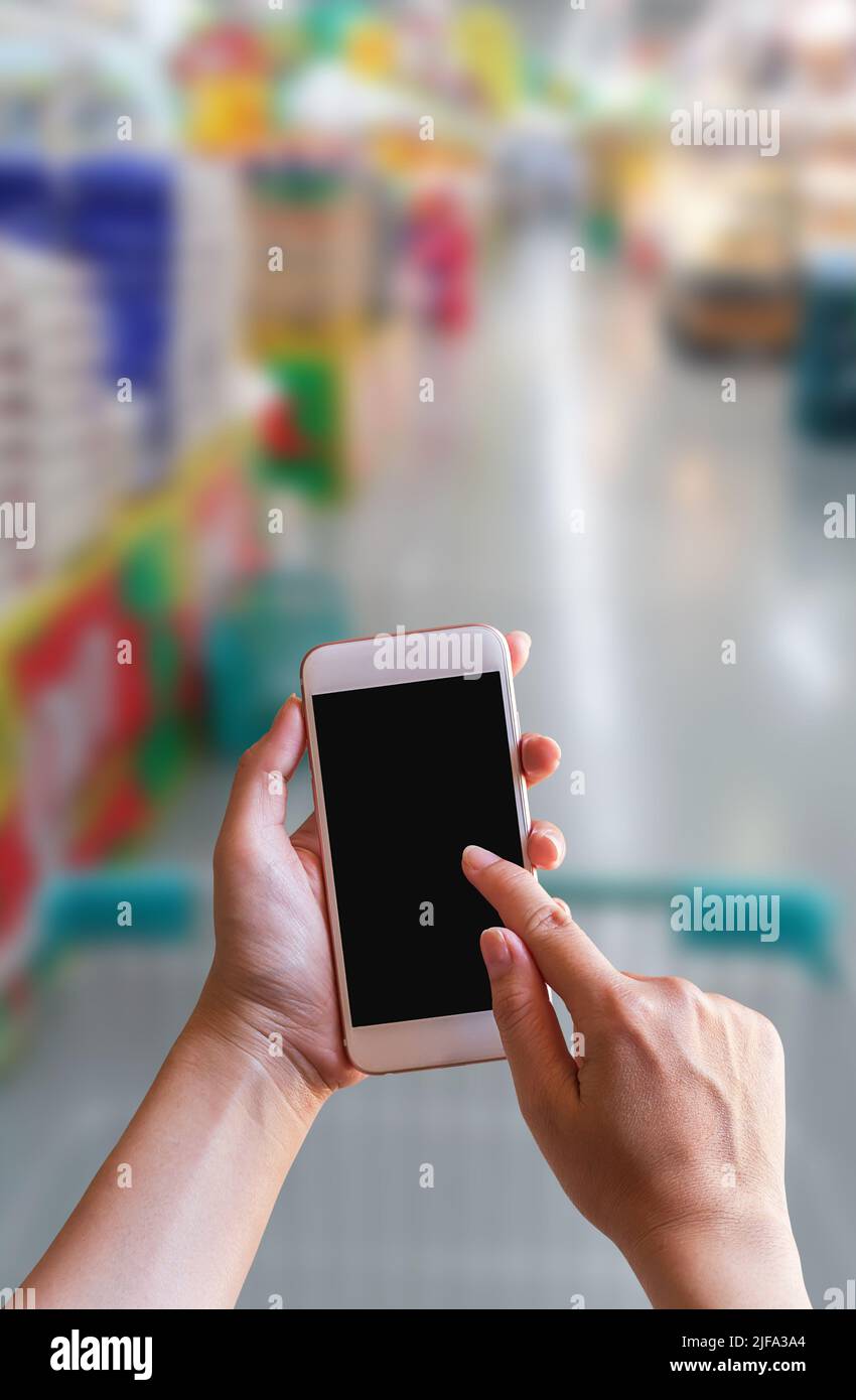 hand holding smart phone with store blurred background Stock Photo - Alamy