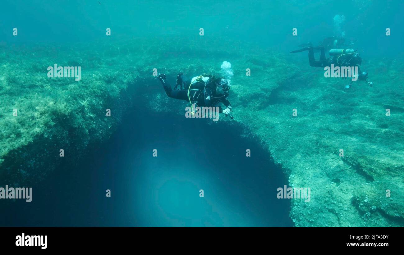 Female scuba diver near the exit from the cave. Cave diving in ...