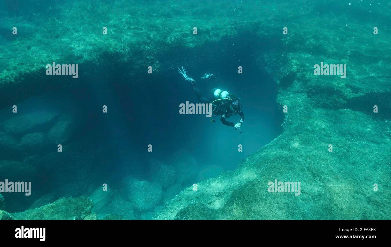 Female scuba diver near the exit from the cave. Cave diving in ...