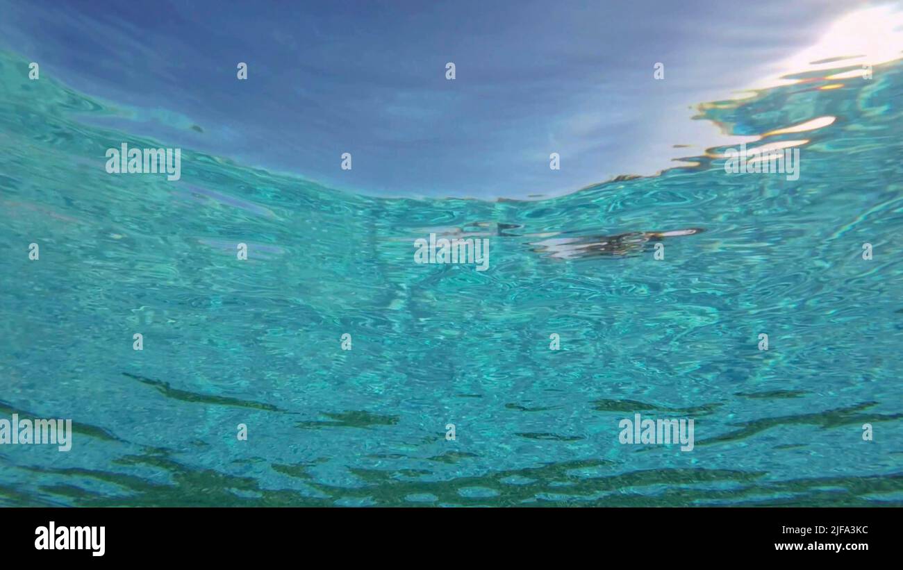 Sunlight rays shining through blue ocean surface. Natural underwater ...