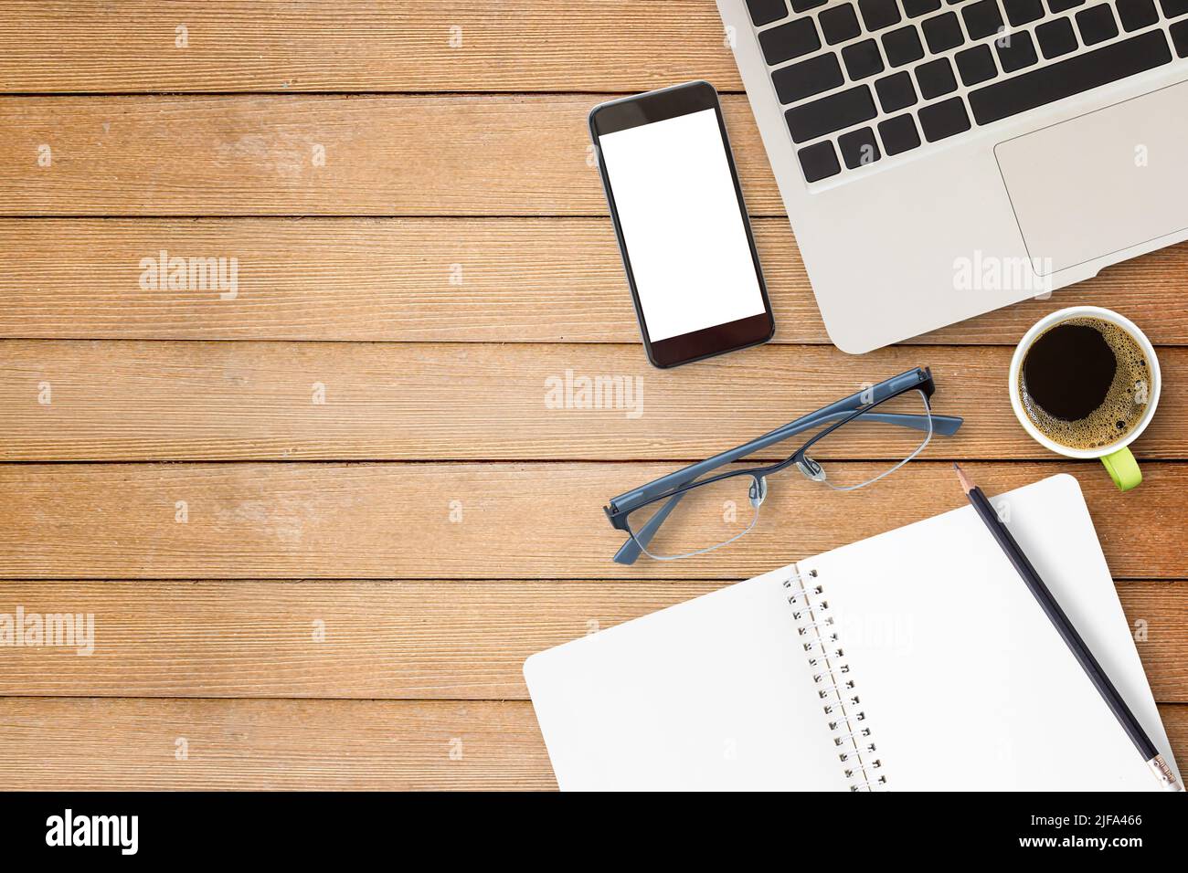 Laptop computer and smart phone with cup of coffee on wooden table. Top ...