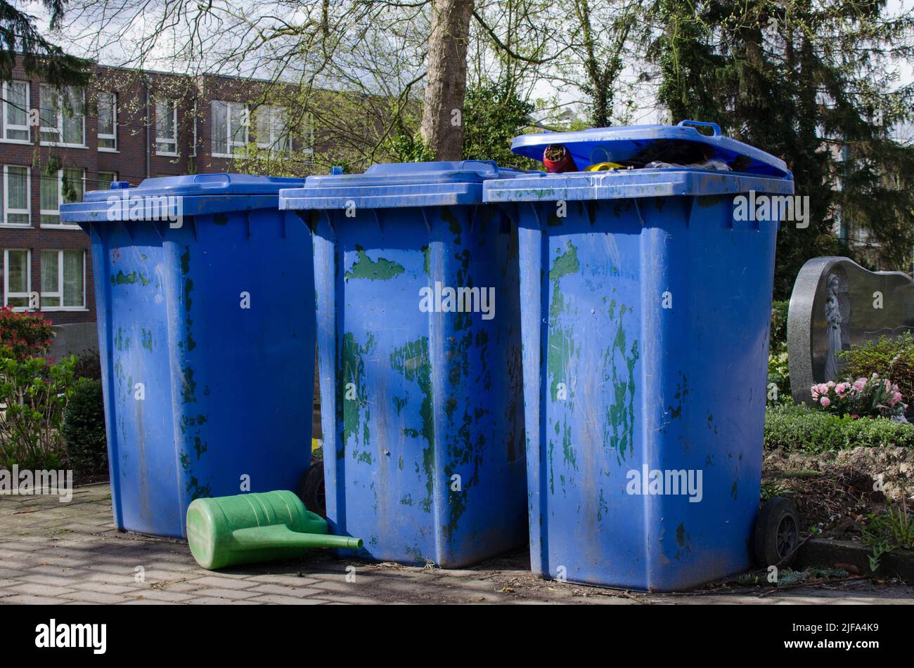 group of three large blue trash cans on a cemetery in germany Stock ...