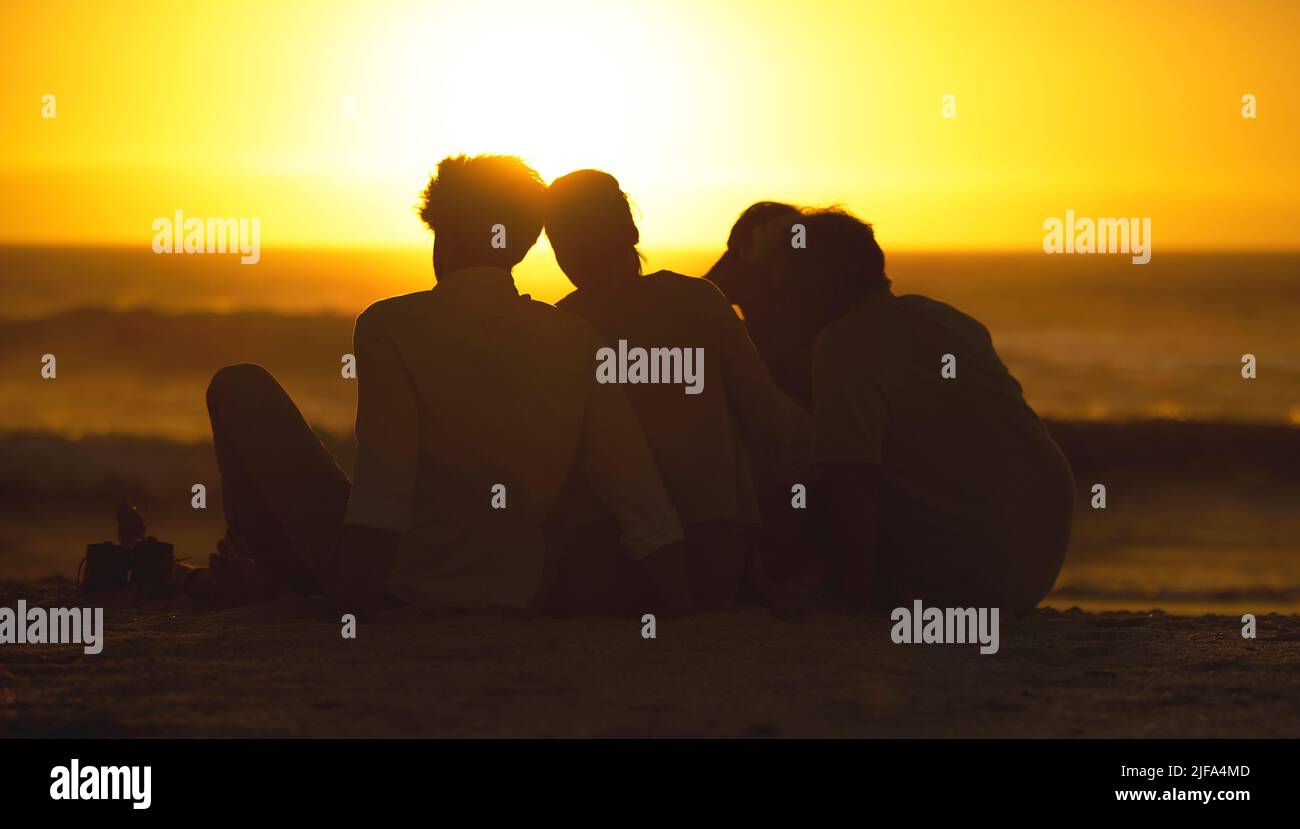 Back of a family enjoying the view of the ocean. Silhouette of a family ...