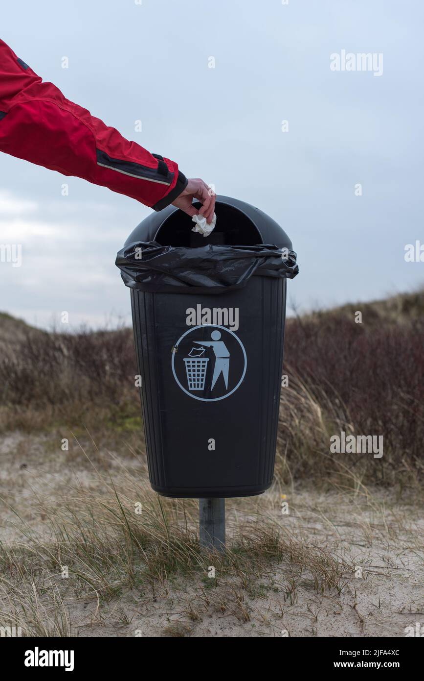 man hand throwing used tissue or paper handkerchief into an empty black ...