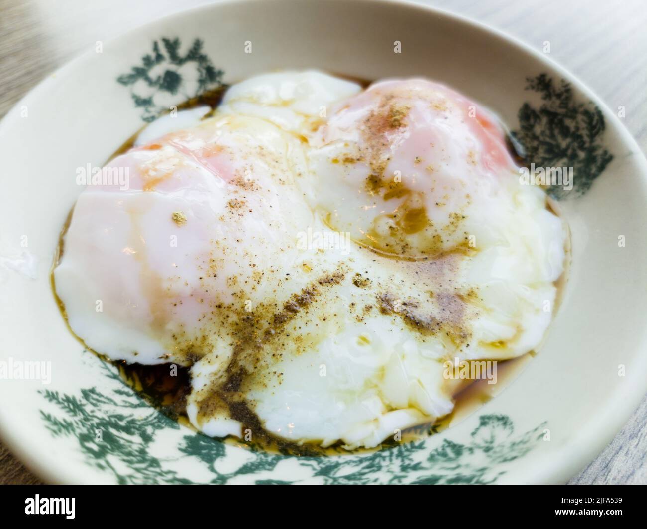 Close-up view two half boiled eggs served with soy sauce and white pepper Stock Photo - Alamy