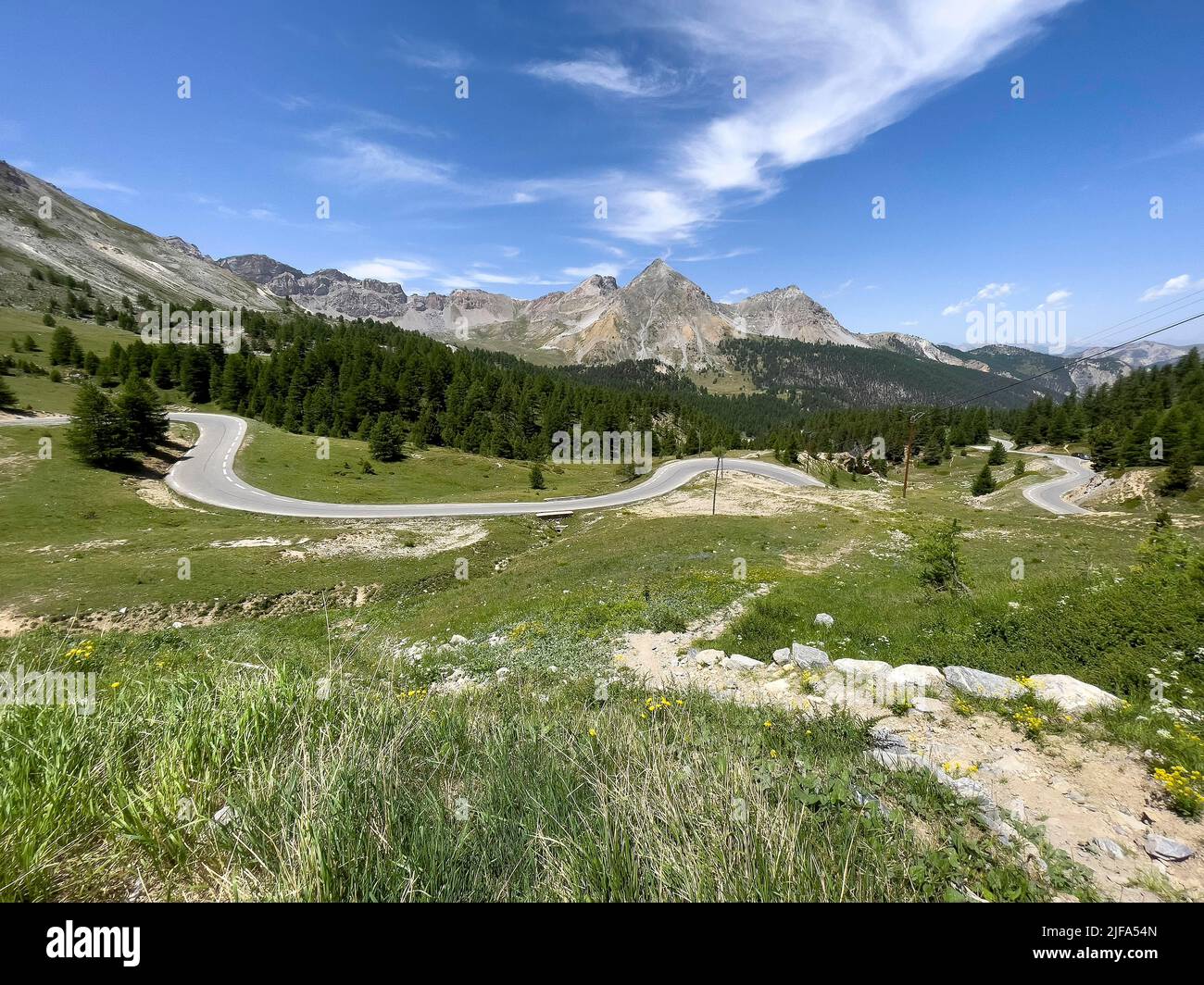 View over wild alpine meadow on winding alpine road Mountain road in ...