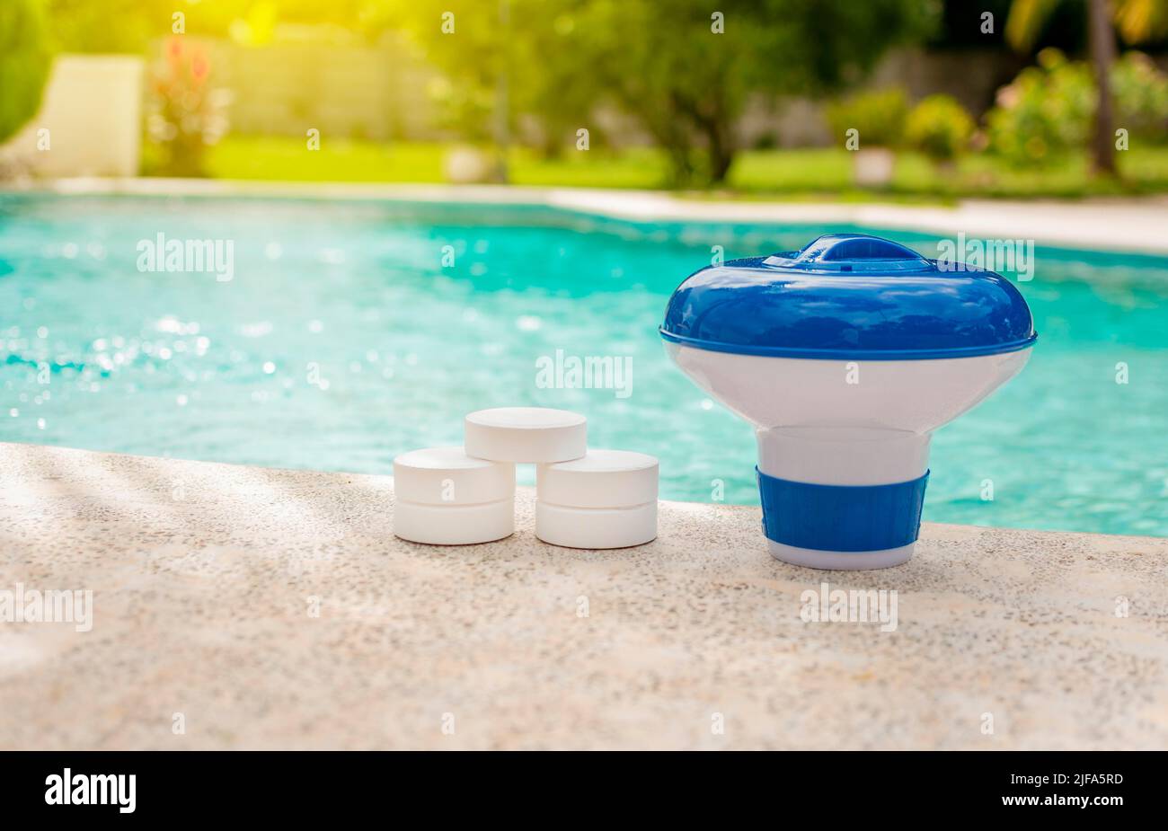 A pool float and chlorine tablets on the edge of a swimming pool ...