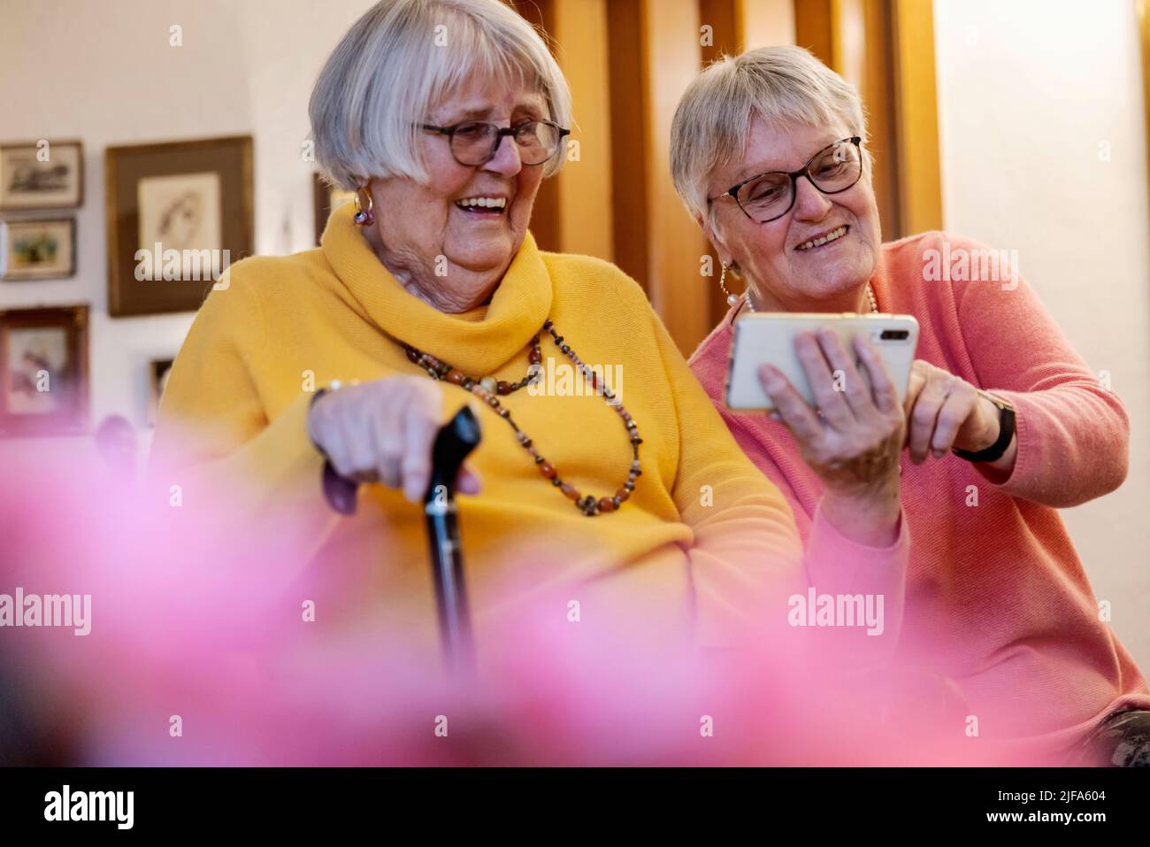 Two senior citizens, sisters, looking at a smartphone at home, Bocholt ...