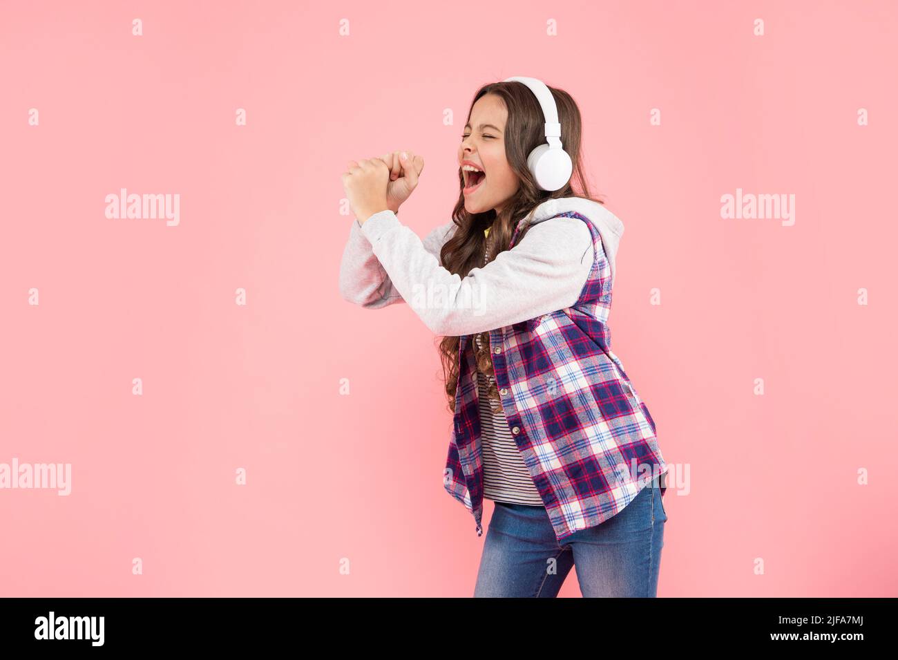 singing child listen music in headphones on pink background, modern ...