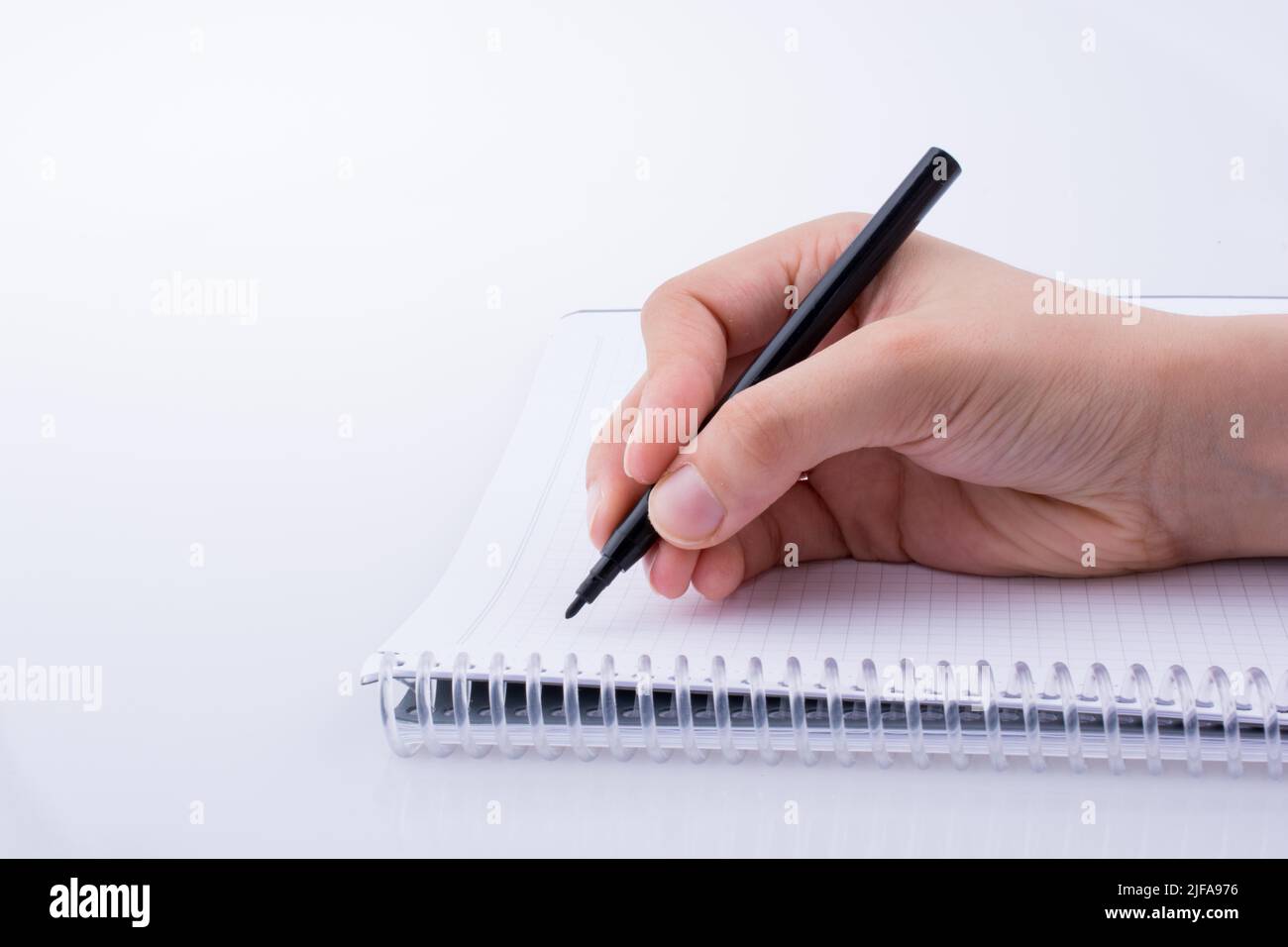 Hand writing on a Notebook with a pen on a white background Stock Photo ...