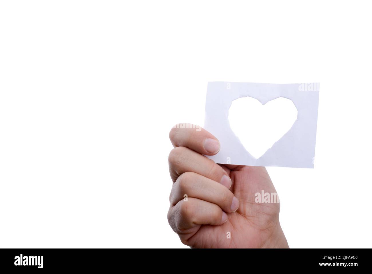 Hand holding a heart shape paper cut out of paper on a white background ...