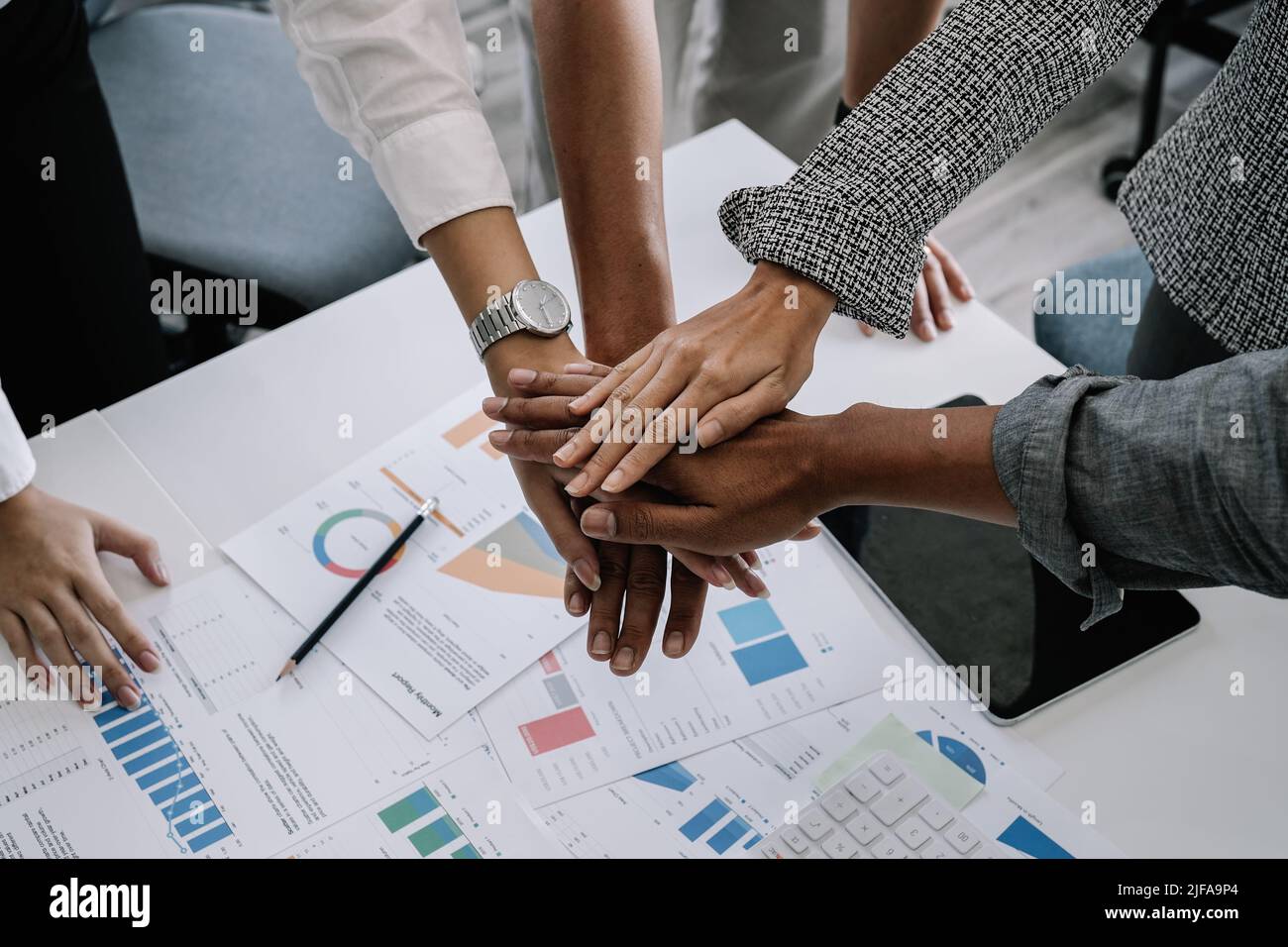 Close up happy diverse business people putting hands together, showing ...