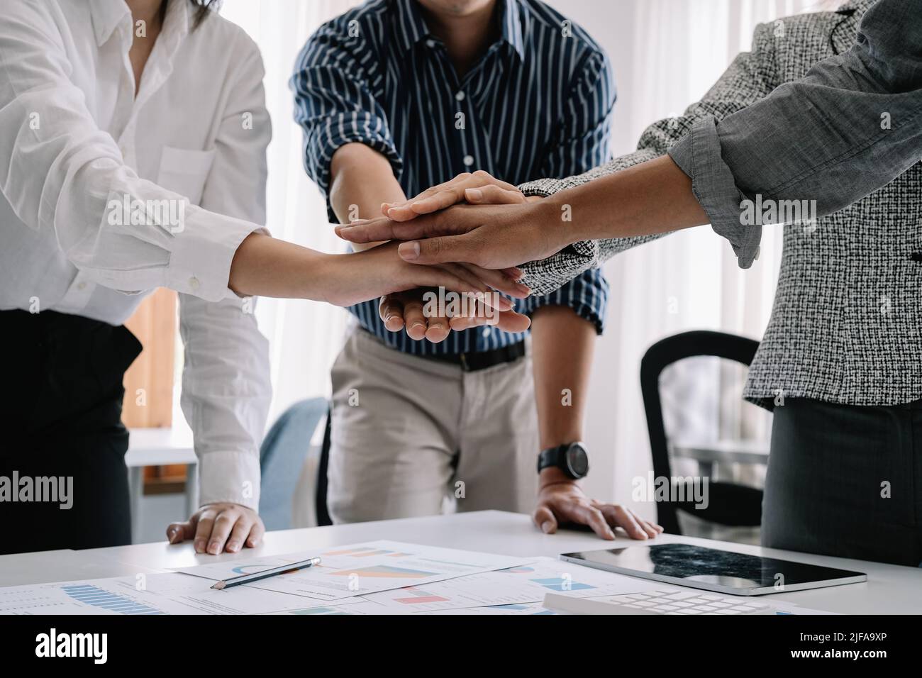 Close up happy diverse business people putting hands together, showing ...