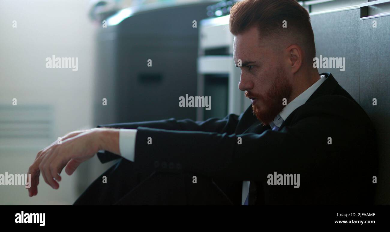 Business man sitting on home floor feeling frustration and anxiety ...