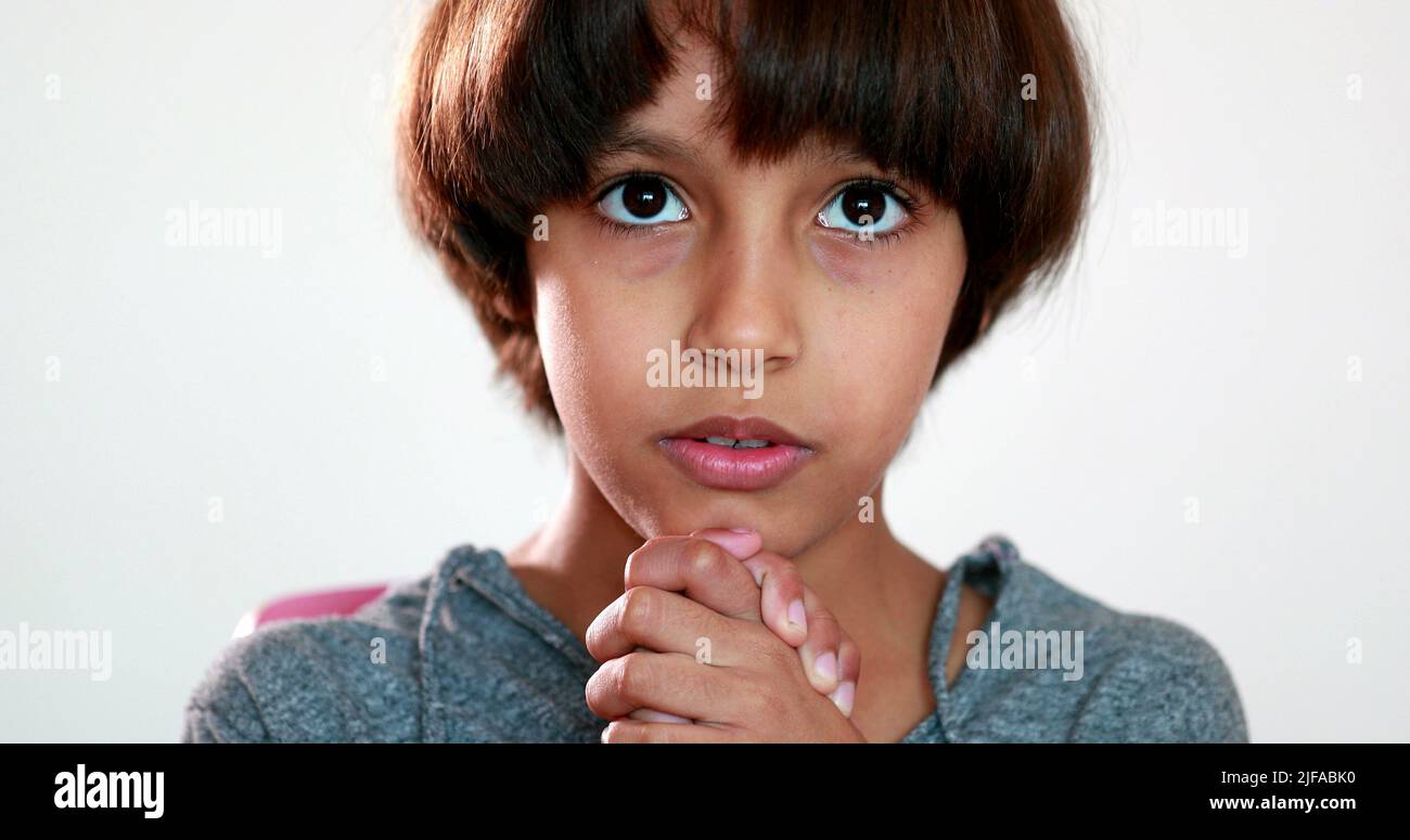 Child boy praying to God with hands held together with closed eyes ...