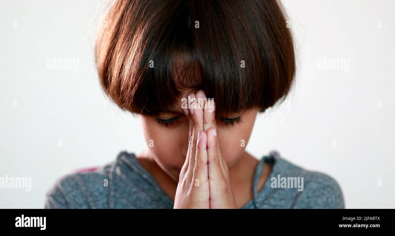 Child boy praying to God with hands held together with closed eyes ...