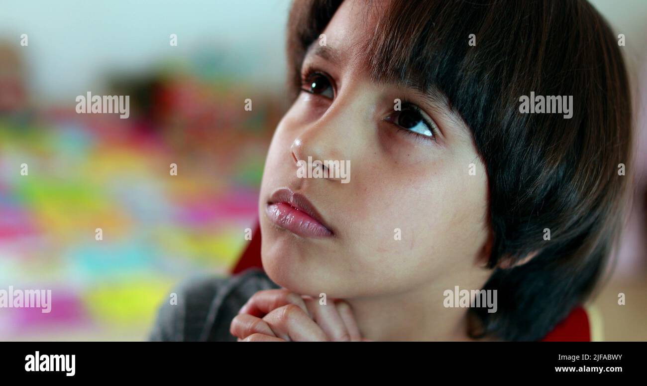 Child boy praying to God with hands held together with closed eyes ...