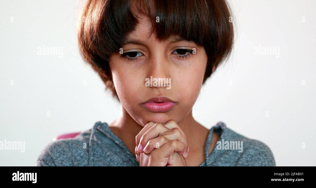 Child boy praying to God with hands held together with closed eyes ...