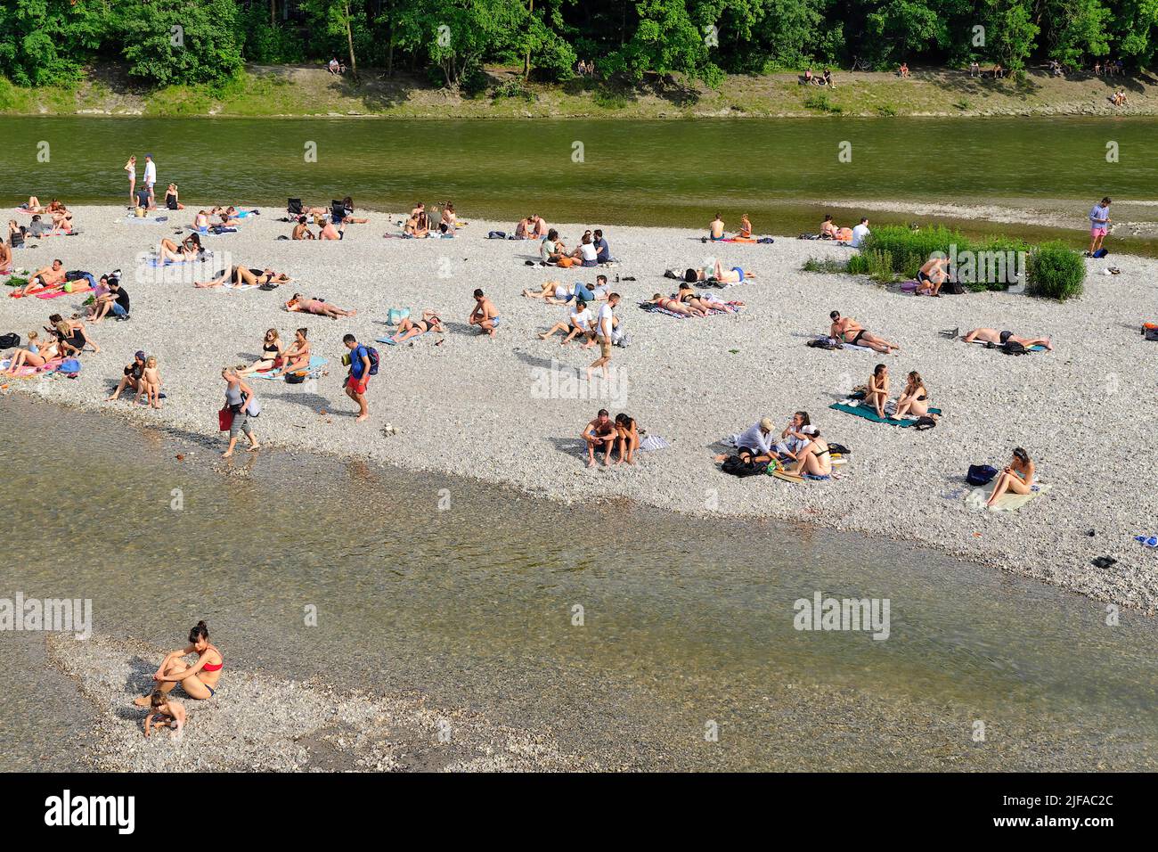People bathing on a gravel bank in the Isar river, Munich, Bavaria ...