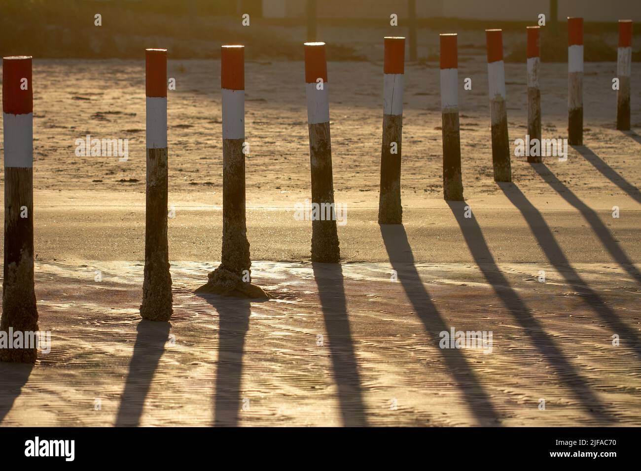 Red and white painted wooden bollard markers in the lagoon Stock Photo ...