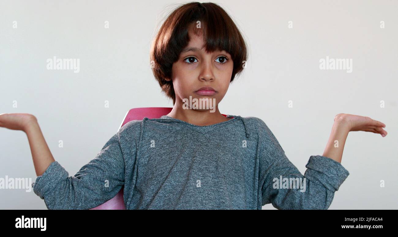 Clueless young boy shrugging, doubtful child mixed race Stock Photo - Alamy