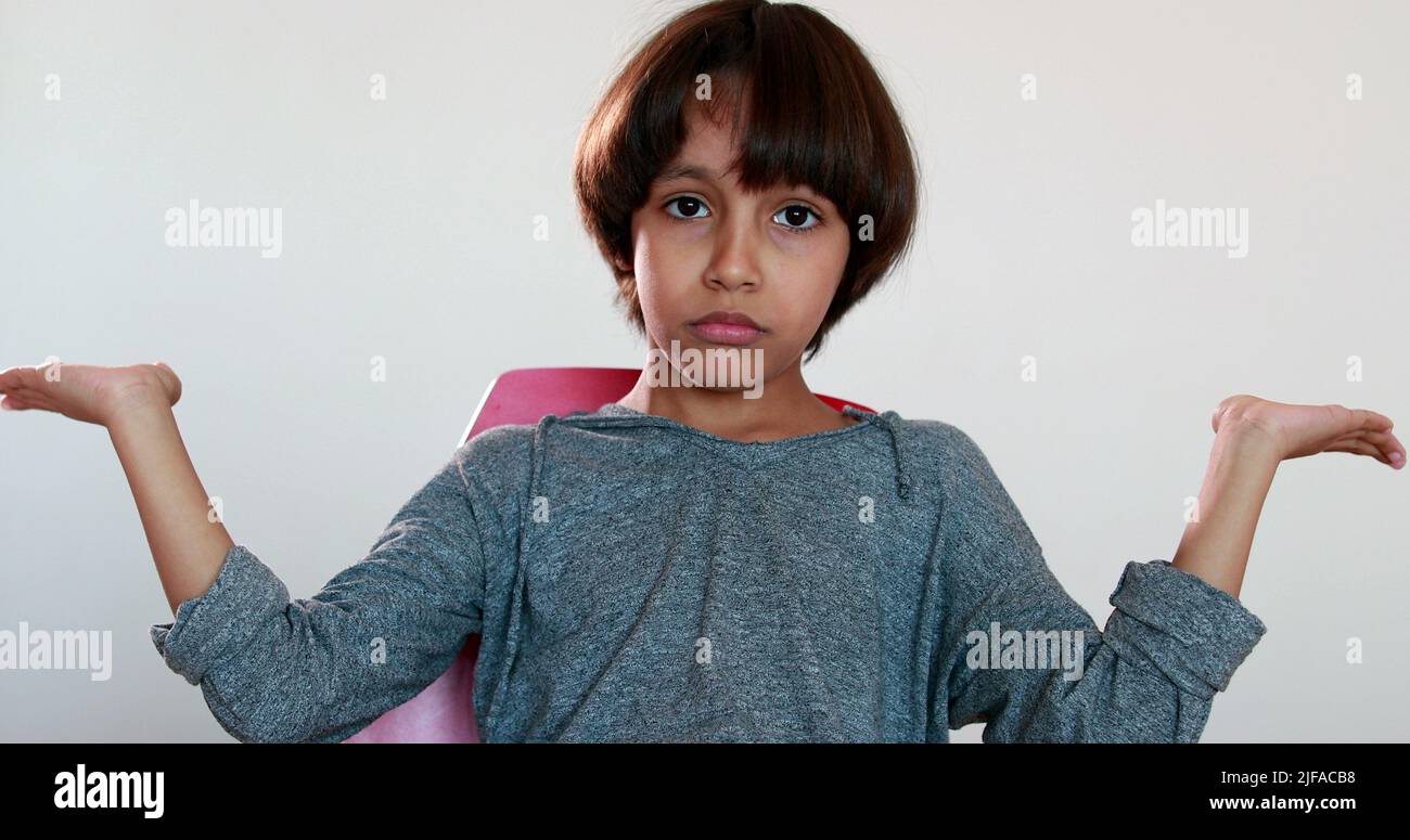 Clueless young boy shrugging, doubtful child mixed race Stock Photo - Alamy