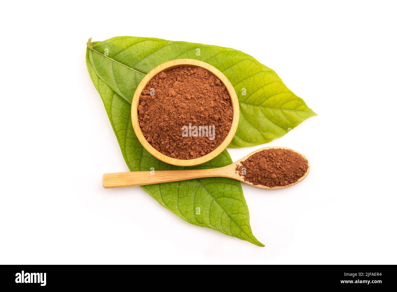 Top view Pile of Cocoa powder in wooden spoon and green leaf isolated ...