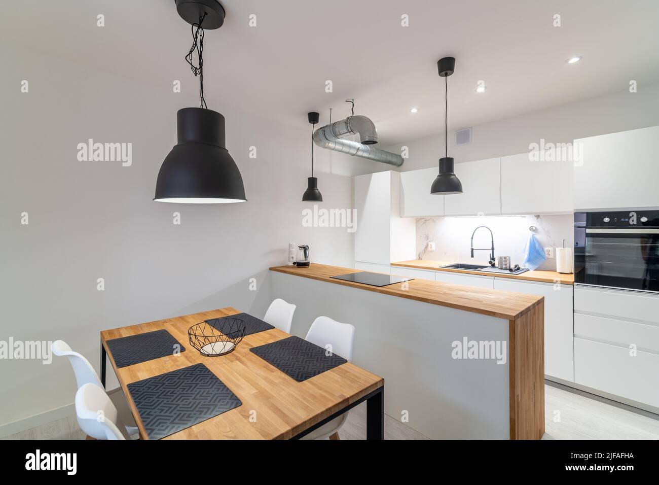 Modern kitchen with a dining area and a counter Stock Photo - Alamy