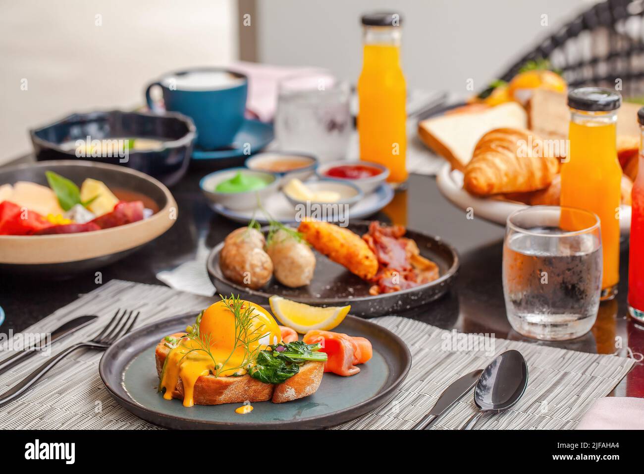 Delicious breakfast in luxury hotel. Table with plates full of various ...