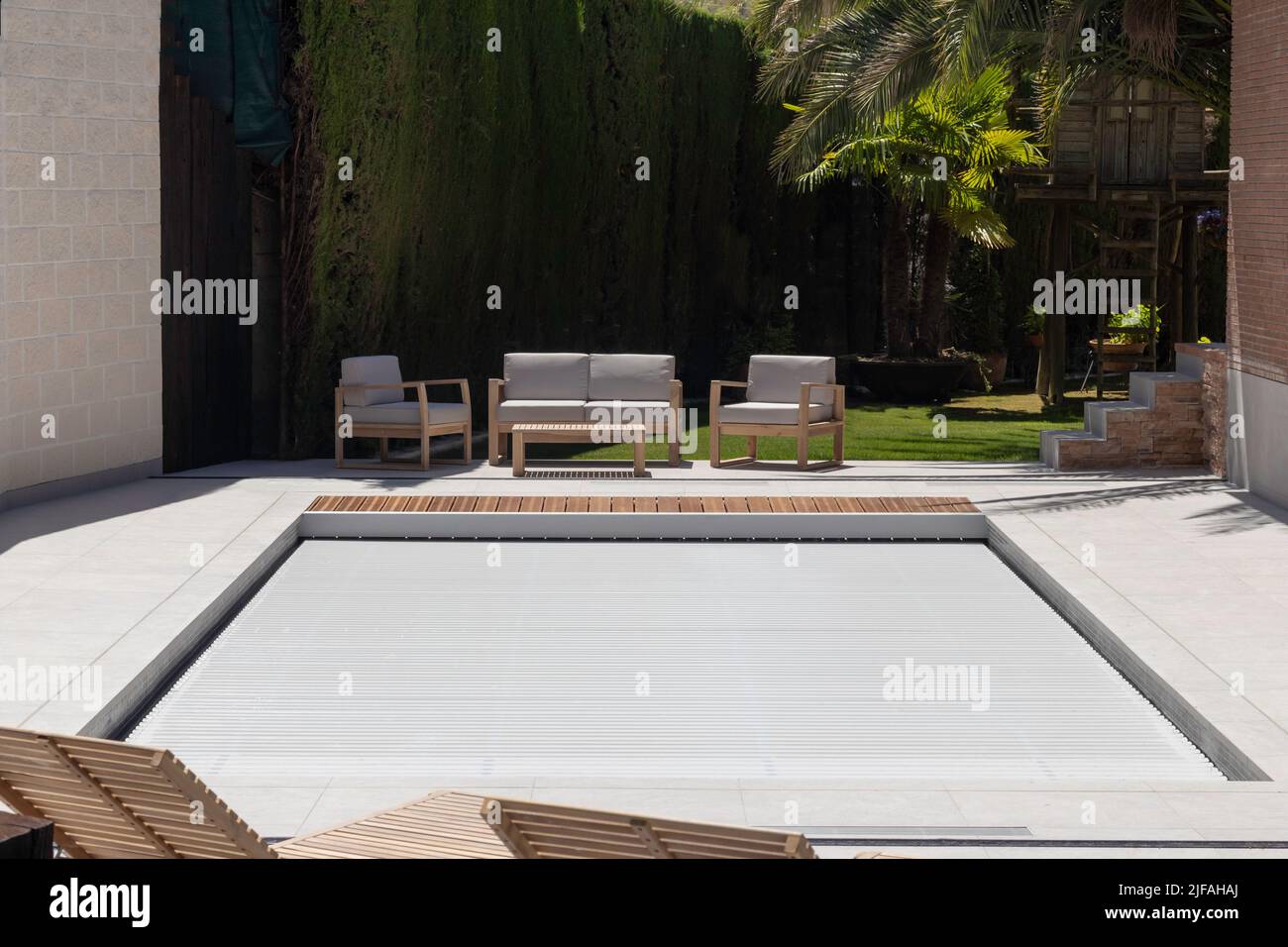 Front view of beautiful swimming pool with closed shutter in summer ...