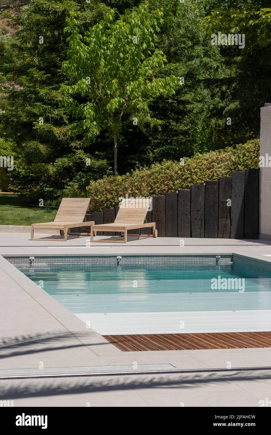 Vertical view of swimming pool area in the garden of the house with ...