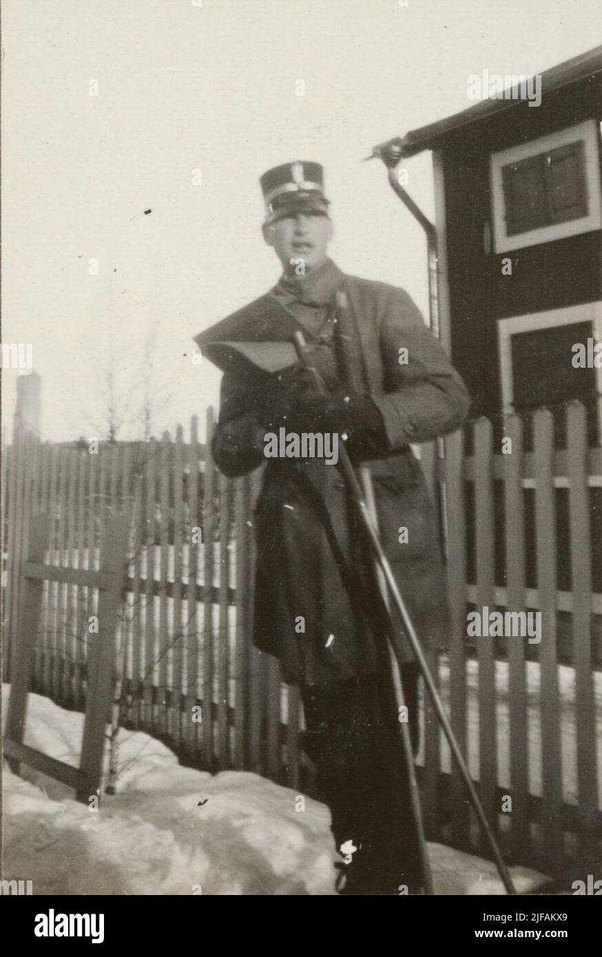 A soldier on skis reads the map in front of a building. Portrait ...