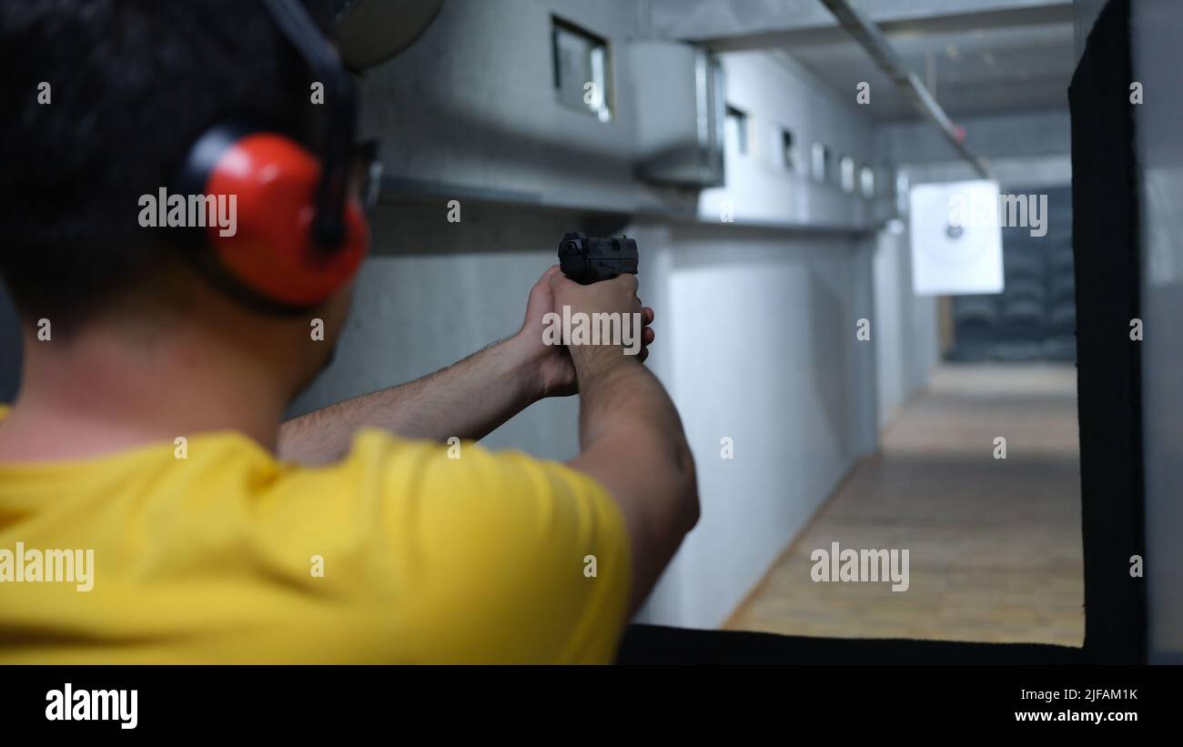 Shooter shoots from pistol in shooting range closeup Stock Photo - Alamy