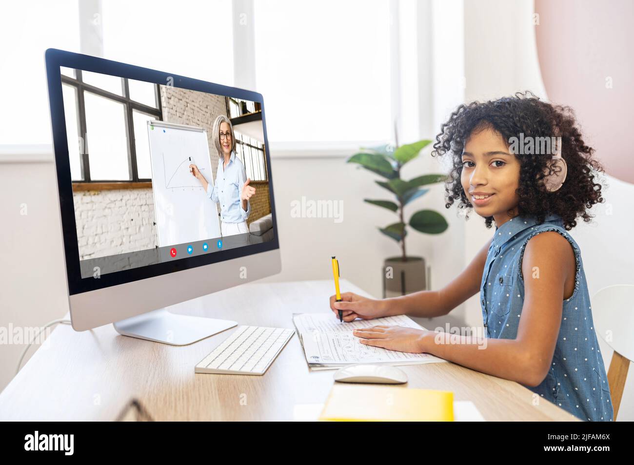 Homeschooling and e-studying concept. Cute biracial girl watching ...