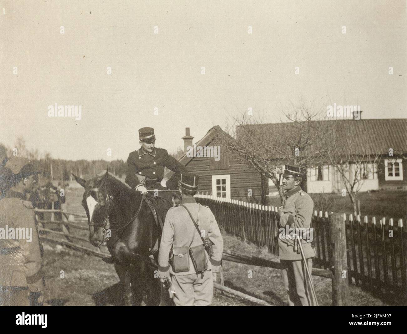 An officer on a horse with three soldiers standing in a deed around him ...