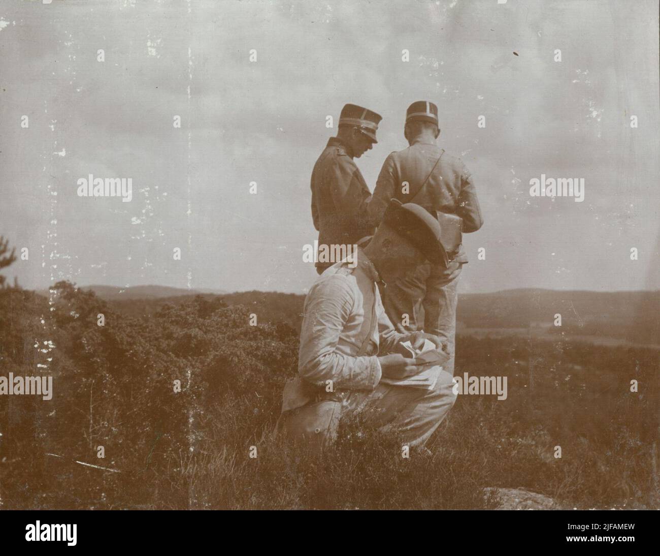 Three soldiers on field exercise surrounded by hilly landscapes and ...